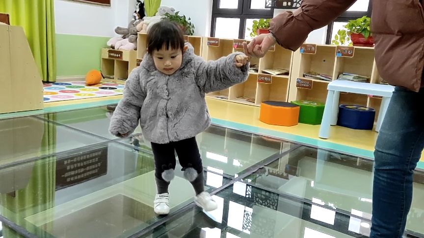 幼儿园的玻璃栈道把小红帽吓坏了,小手紧紧拉住姥姥