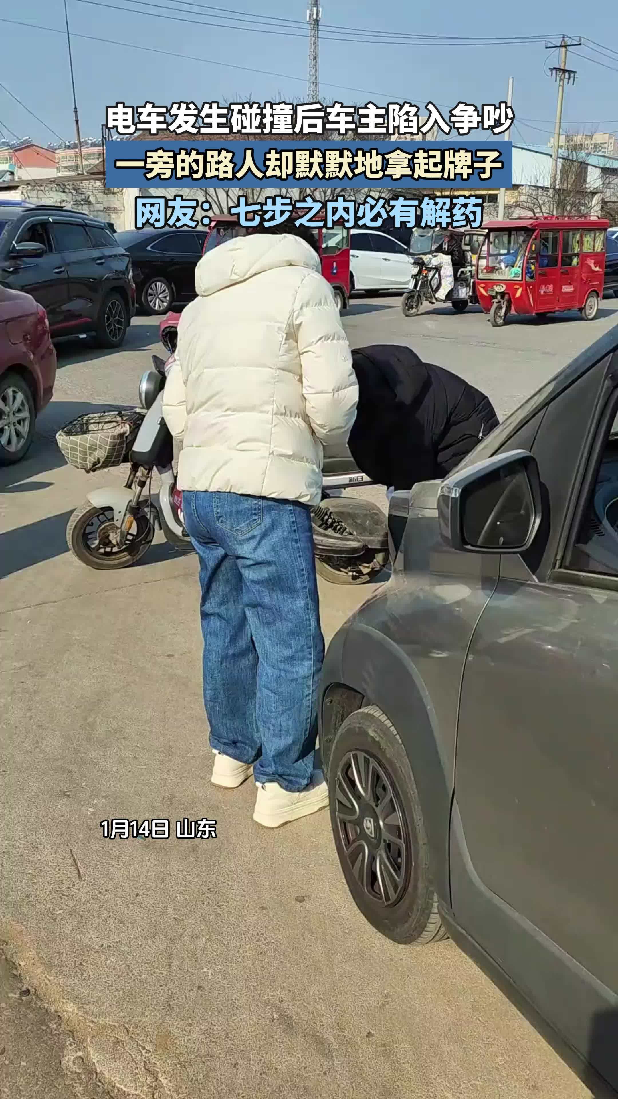 电车发生碰撞后车主陷入争吵,一旁的路人却默默地拿起牌子。