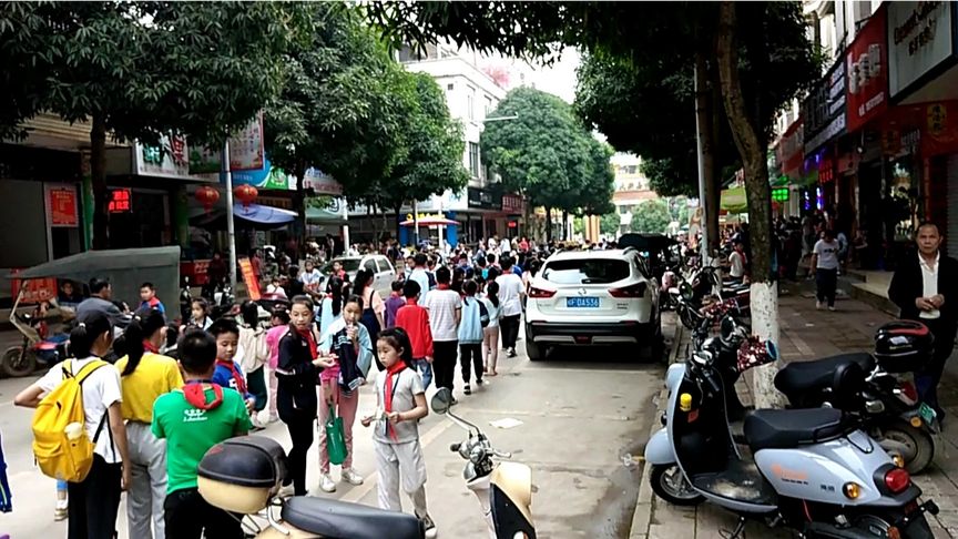 大新二小学生排长队走进学校大门口