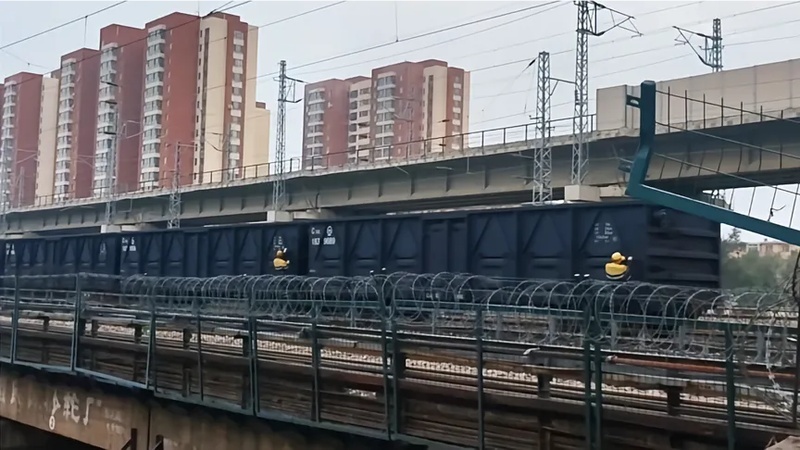 C70E型敞车车列正在缓缓经过铁路大桥,敞车上是勇敢的调车员