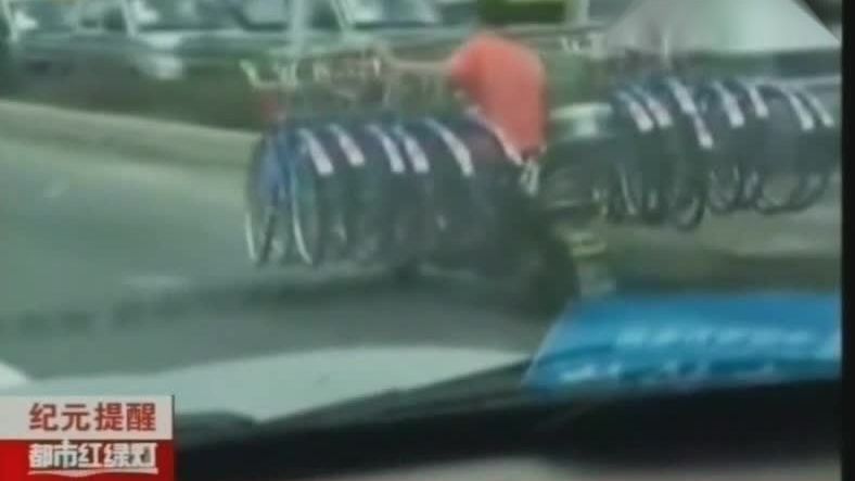 安全隐患,电动车驾驶人用1根竹竿扛起16台自行车