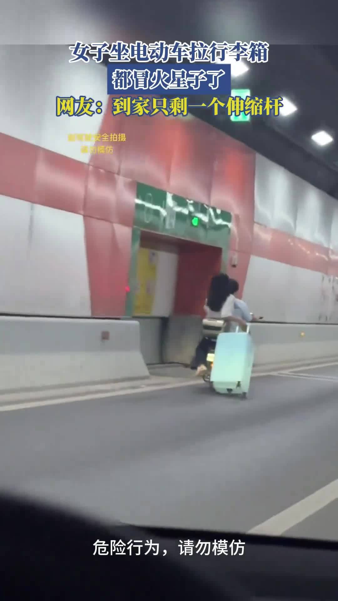 女子坐电动车拉行李箱,都冒火星子了,网友:到家只剩一个伸缩杆