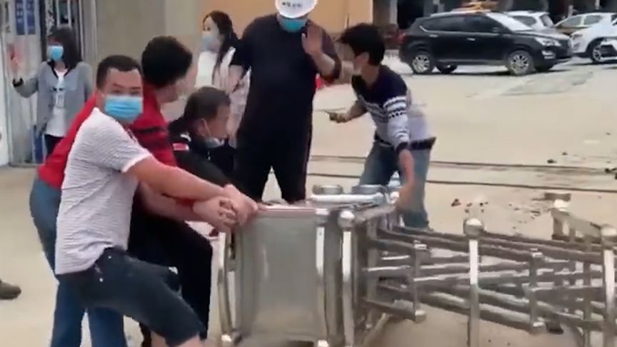 广西一城管局局长不配合测温强闯学校 被拦后派挖掘机强拆校门