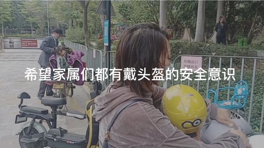 某小学的家长上学送小孩骑电动车,没有带头盔 ,没有安全意识 ,