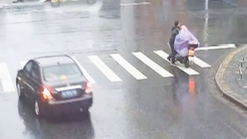 大雨天 女子骑电动车碰撞行人后倒地 交警毫不犹豫脱衣为她挡雨