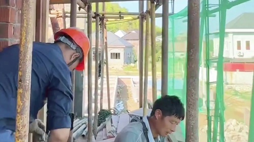 姨父和新来的老师傅正在安装构造柱模板