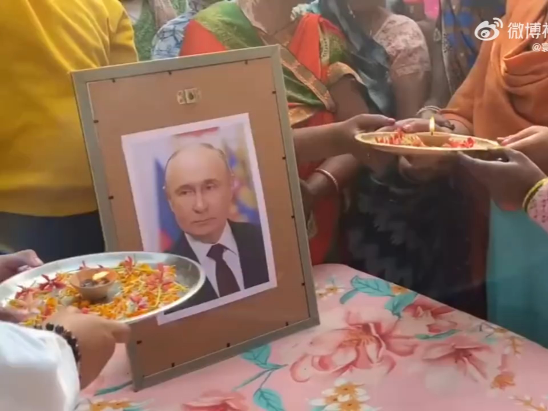 印度民众欢迎普京访问:聚在普京照片周围,手持盘子绕圈