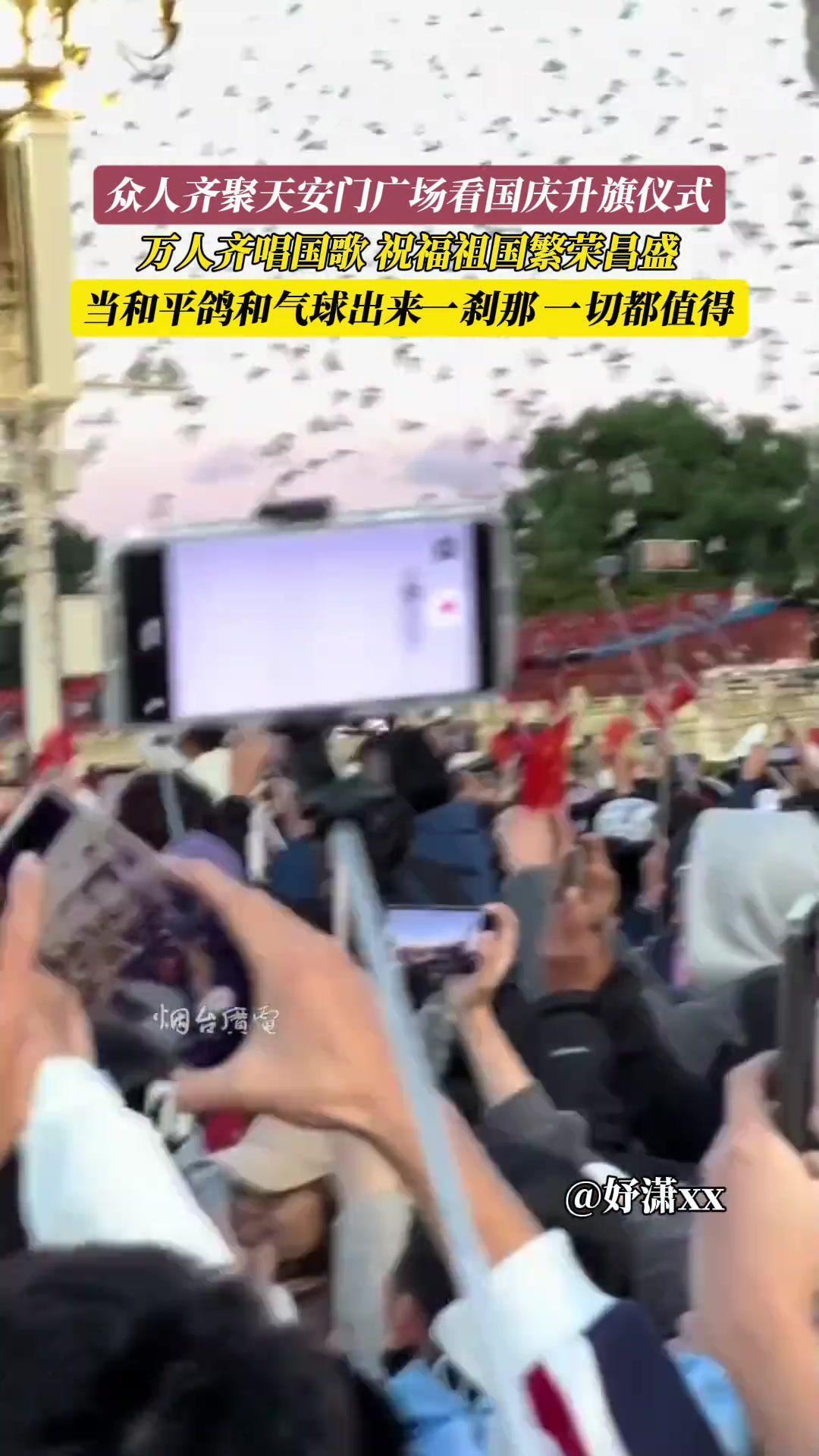 10月1日,北京。众人齐聚天安门广场看升旗仪式,当和平鸽和气球放飞一...
