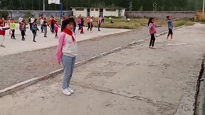 乡村小学生在操场上做新体操,孩子们做的很阳光