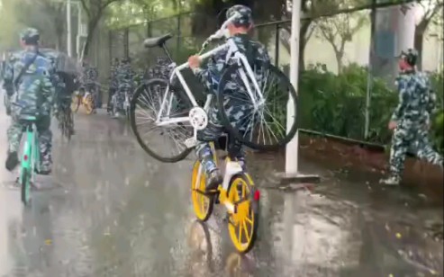 “下雨了,因为我的车没有挡泥板,所以我扛着我的车骑共享单车回宿舍”