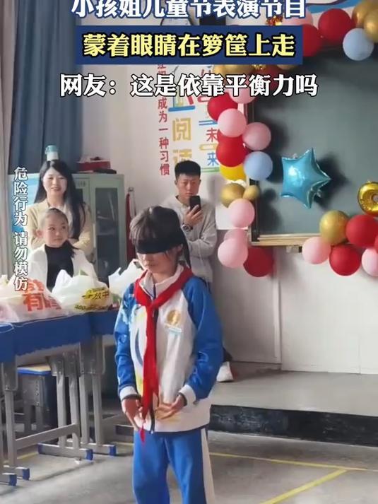 小孩姐儿童节表演节目,蒙着眼睛在箩筐上走