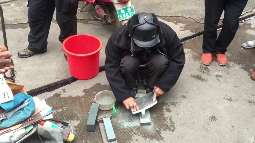 实拍大冷天在柳州街边磨刀的老师傅,磨一把菜刀只要5块钱