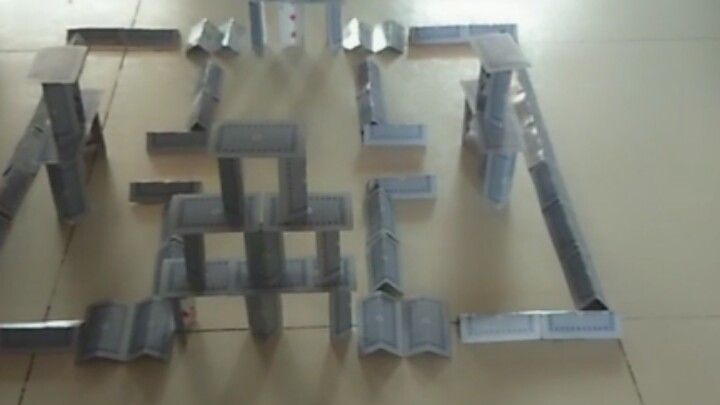 小朋友在实验三角形稳定性,用扑克建城楼,看他建的漂亮城楼