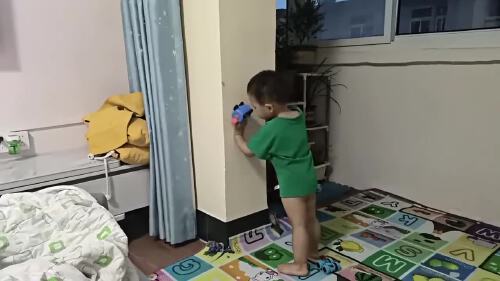 一边往墙上推着小汽车,还得继续看着电视,不时的还得捧场笑笑