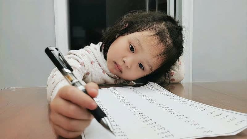 姐姐一边背诵加法口诀表,一边写加法运算结果.