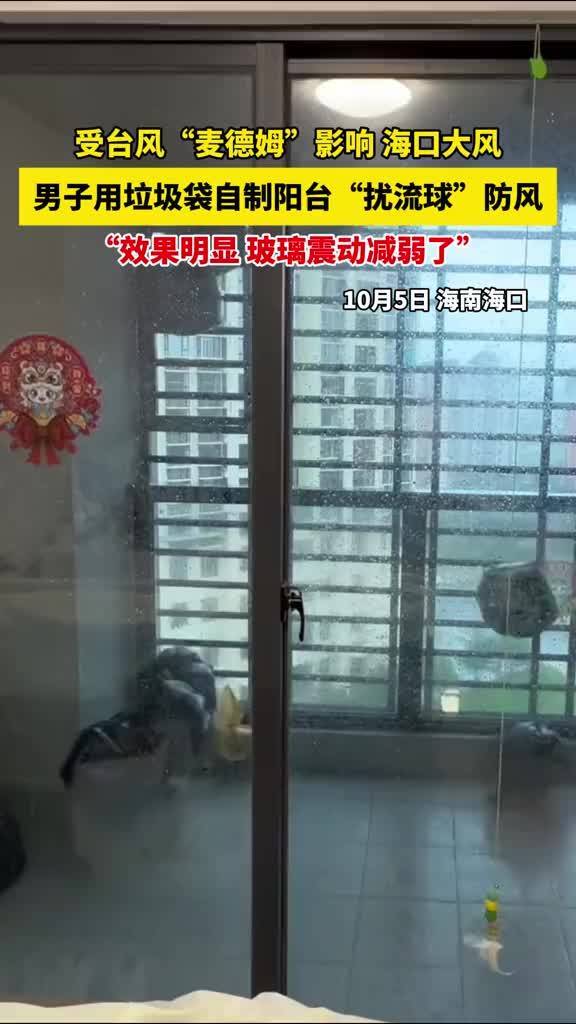 受台风"麦德姆"影响,男子用垃圾袋自制阳台"扰流球"防风