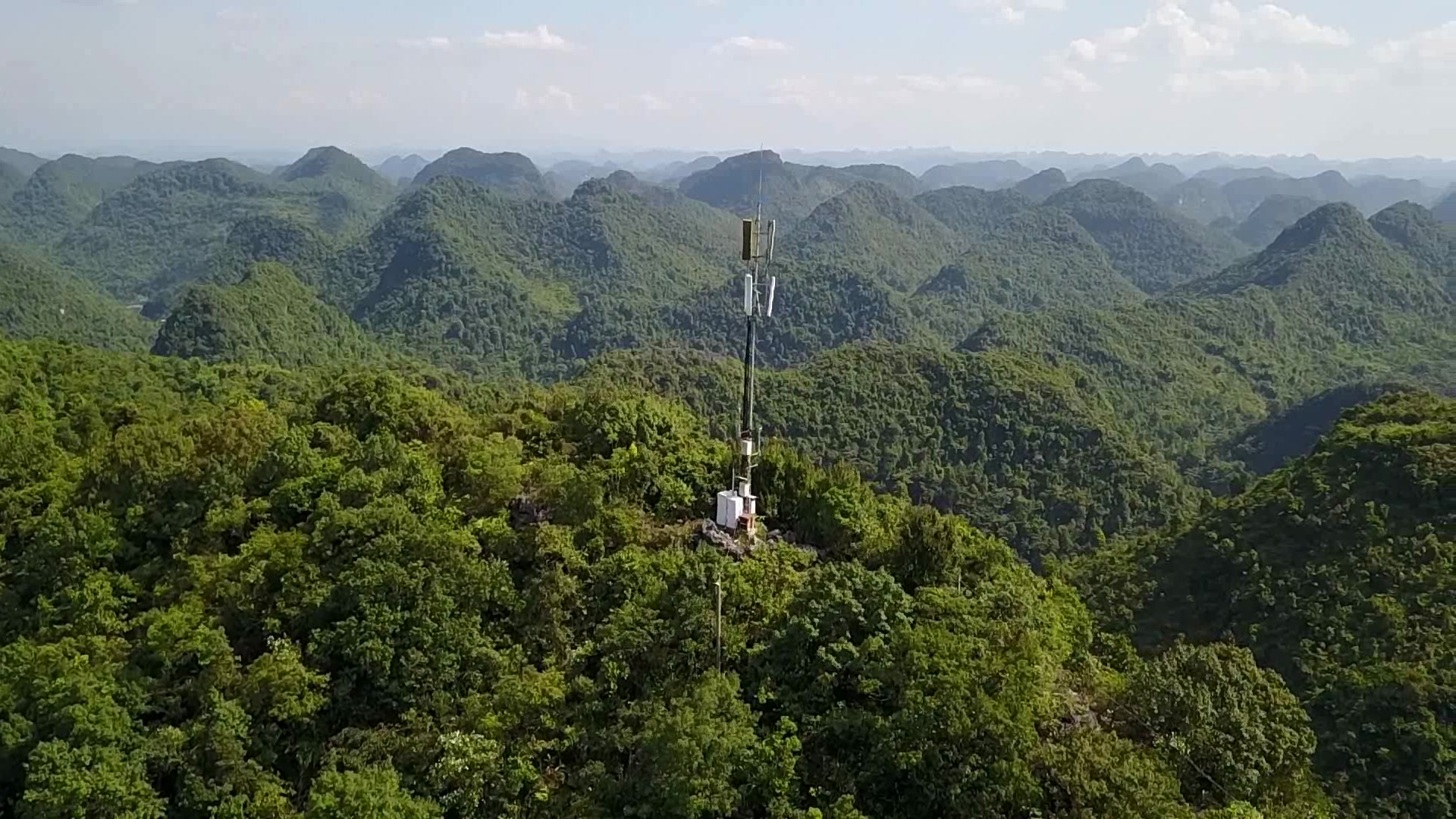 航拍广西南宁市边远地区山顶上的5G信号塔,一个屯两个基站