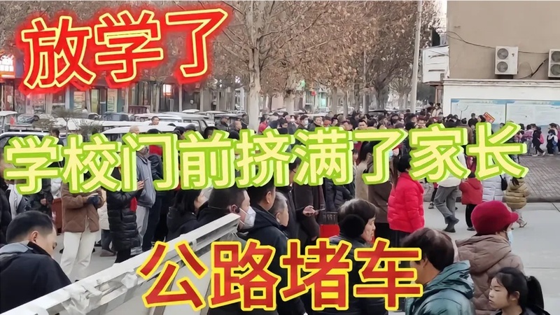 放学了,看看学校门口挤满了家长,公路堵车!