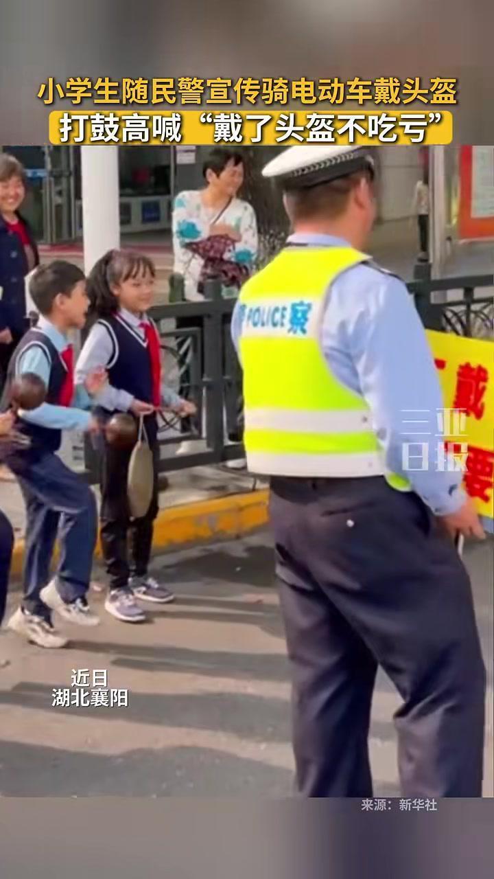 小学生随民警宣传骑电动车戴头盔!打鼓高喊"戴了头盔不吃亏"!