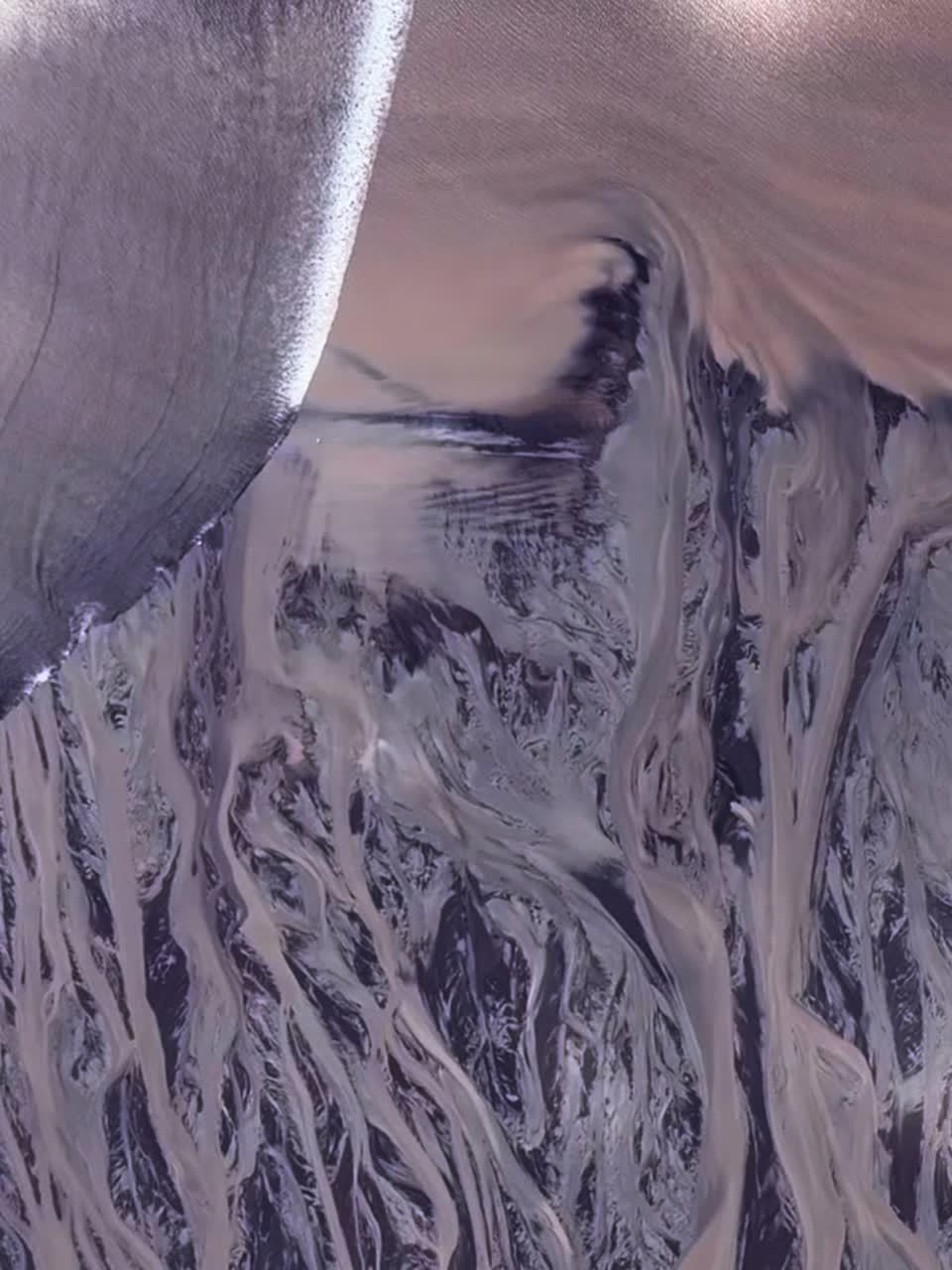 潮水退去,滩涂之上,一幅天然水墨画悄然呈现 水痕与泥沙交织,勾勒出...