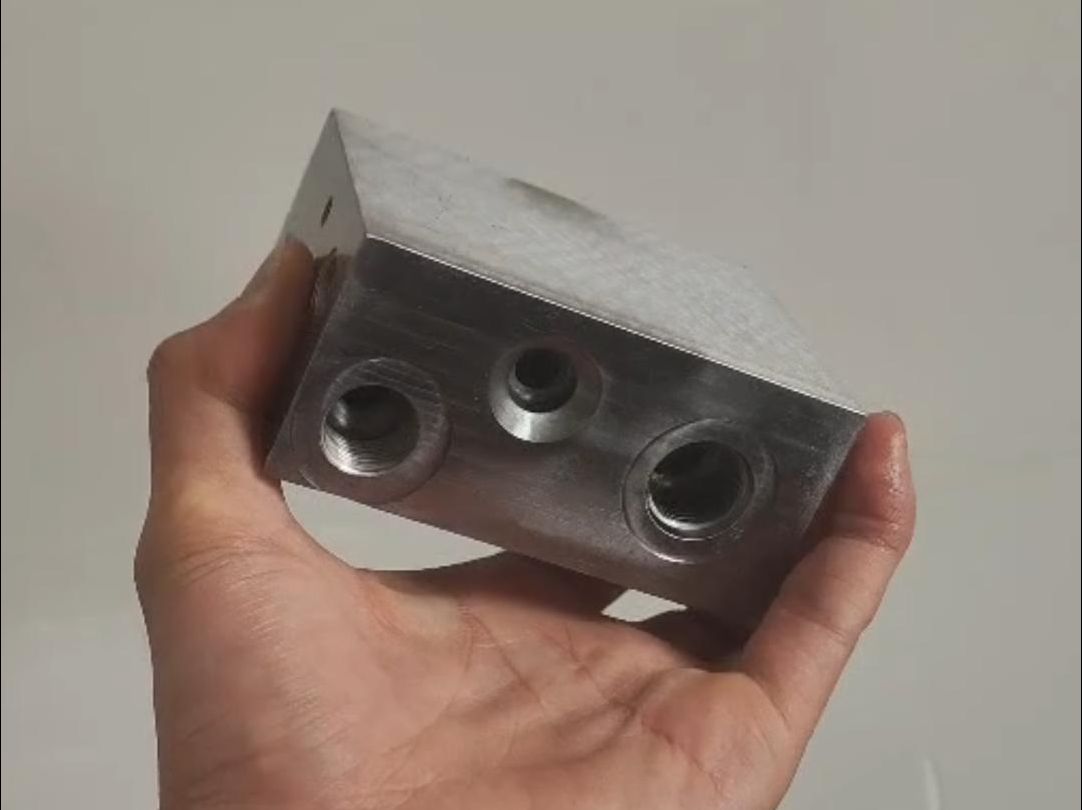 朴丽精工磨粒流使用非牛顿流体磨料,对阀块内孔交叉孔研磨,去除孔内...