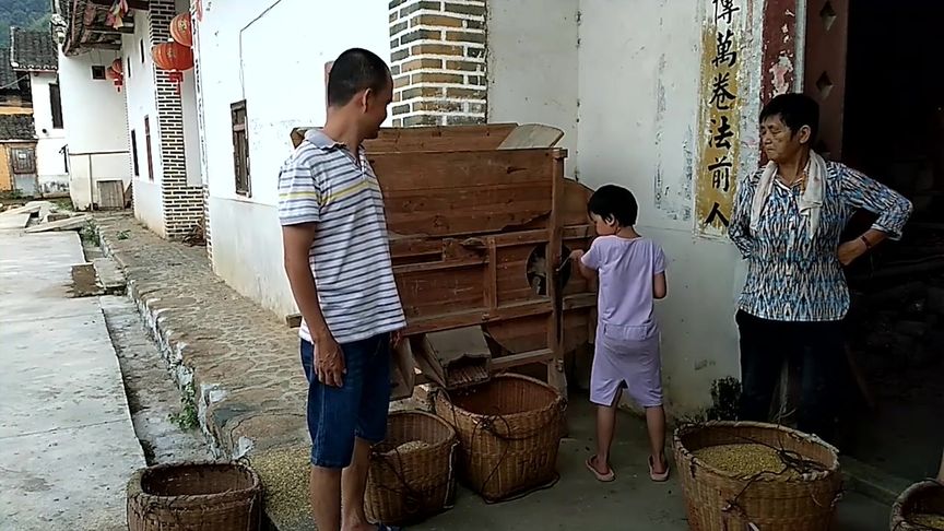 农村里古老的农具风车,却是吹稻谷用的,小孩子没见过竟当玩具玩