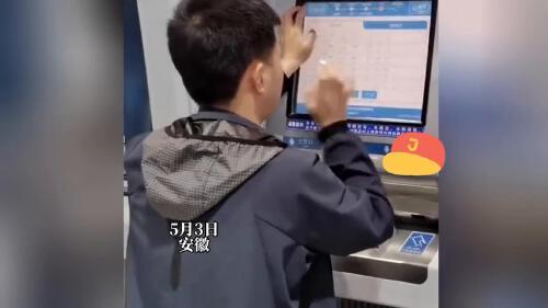 网友偶遇一男子在火车站自动售票机抢票