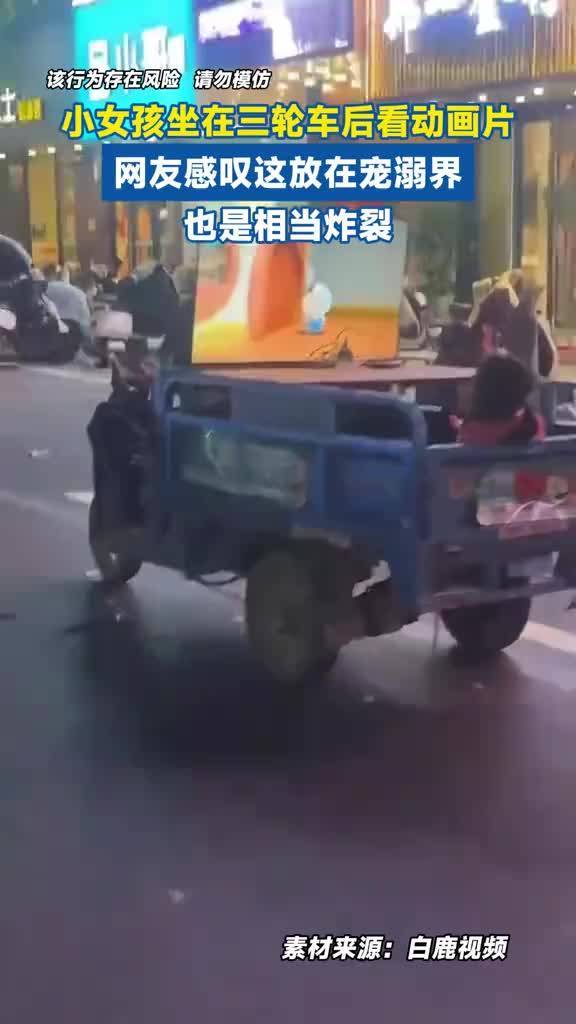 小女孩坐在三轮车后看动画片,网友:这家长也太宠爱了
