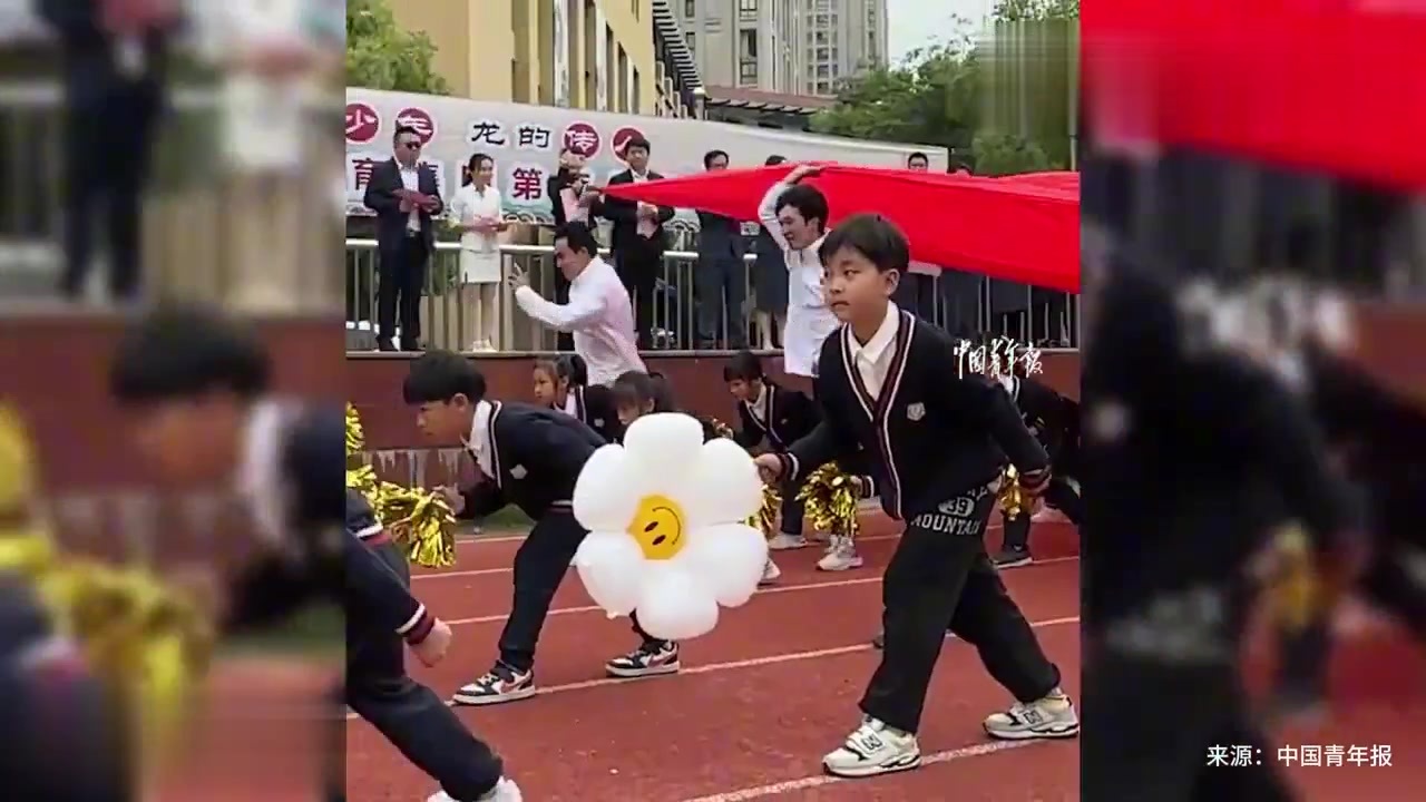 小学运动会开幕式,老师高举国旗奔跑入场,孩子们跟随国旗奔跑