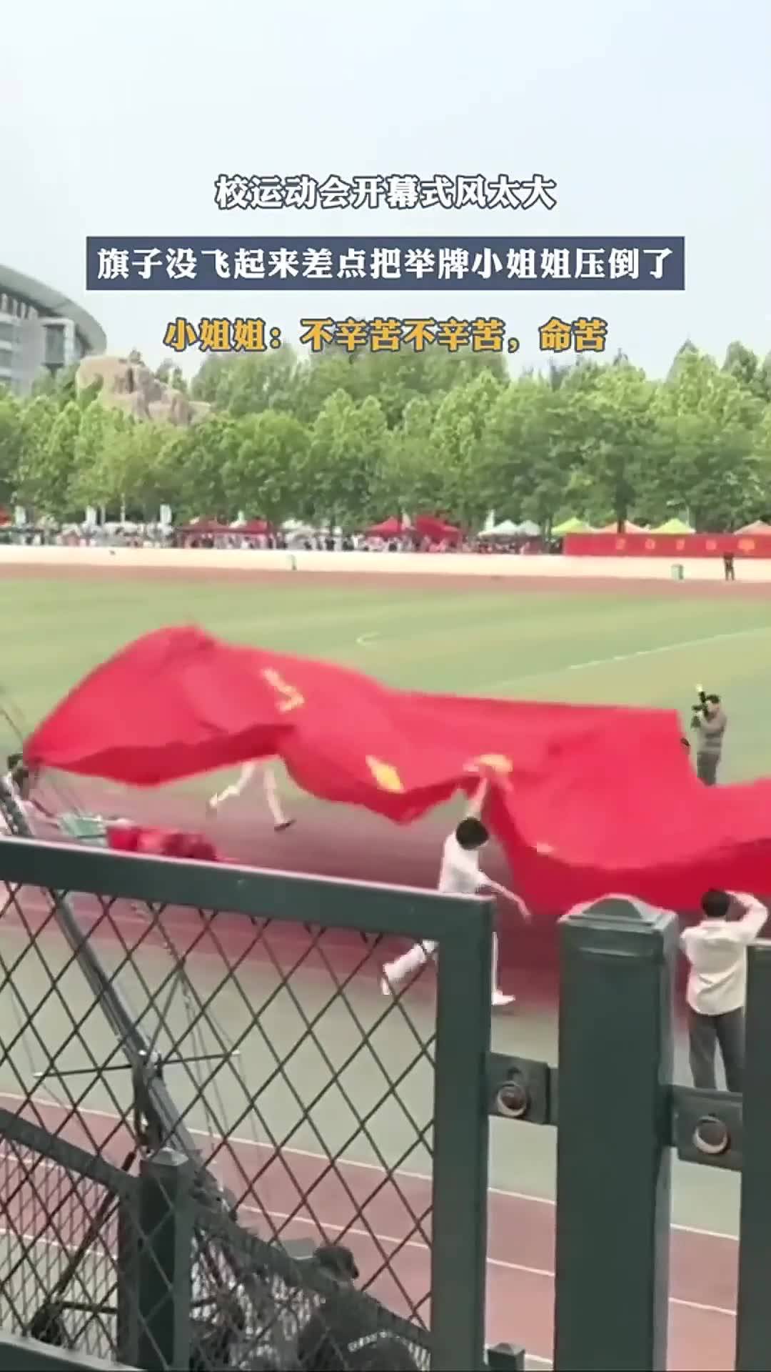 校运动会开幕式风太大,旗子没飞起来差点把举牌小姐姐压倒了
