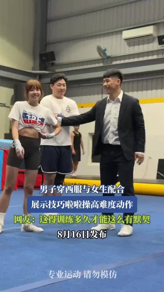 男子穿西服与女生配合,展示技巧啦啦操高难度动作