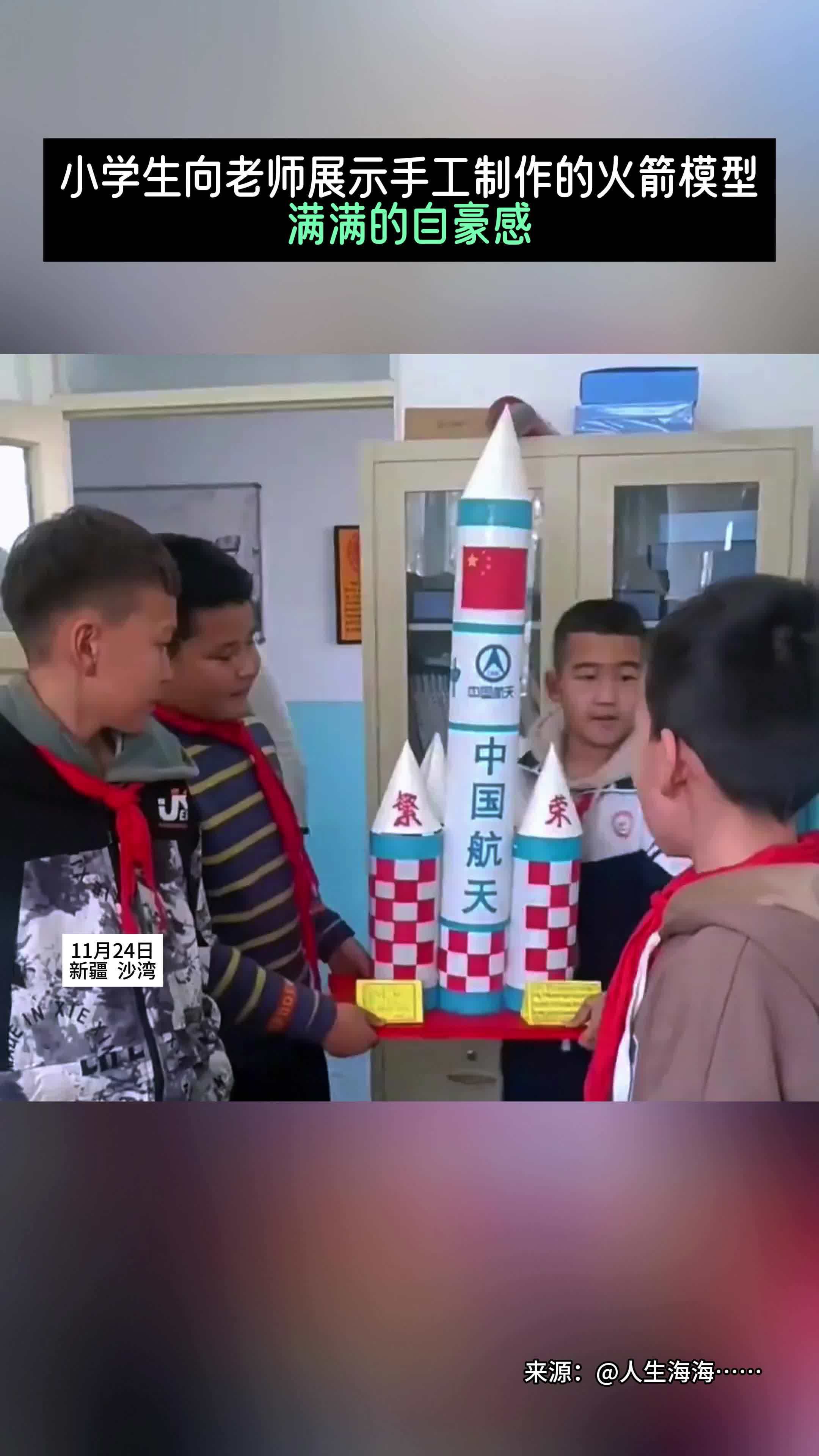 小学生向老师展示手工制作的火箭模型,满满的自豪感