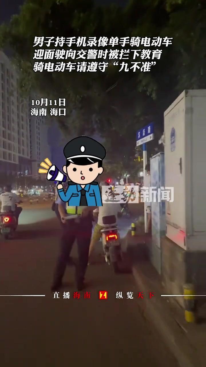 男子持手机录像单手骑电动车,迎面驶向交警时被拦下教育,骑电动车请...