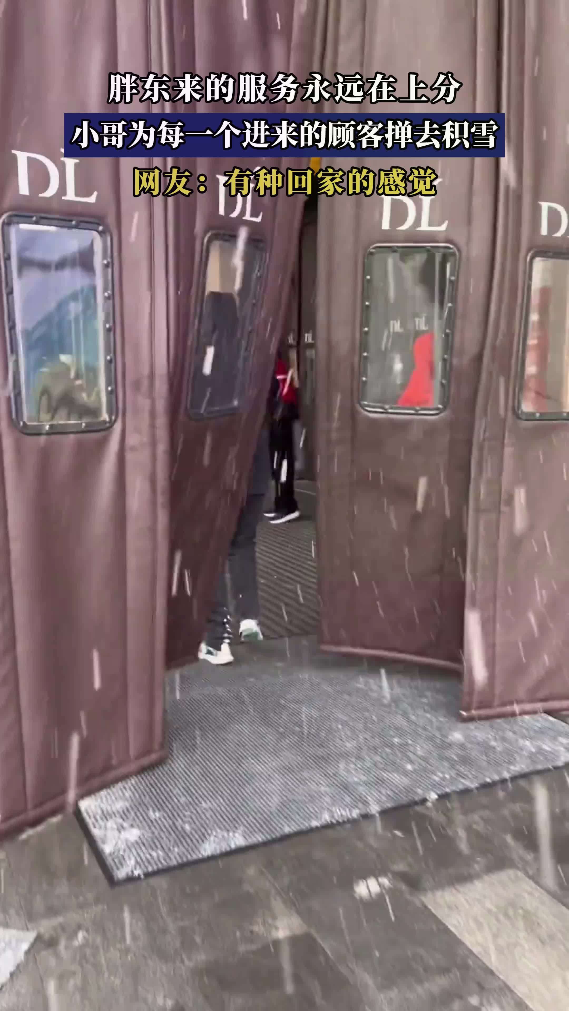 胖东来的服务永远在上分,小哥为每一个进来的顾客掸去积雪