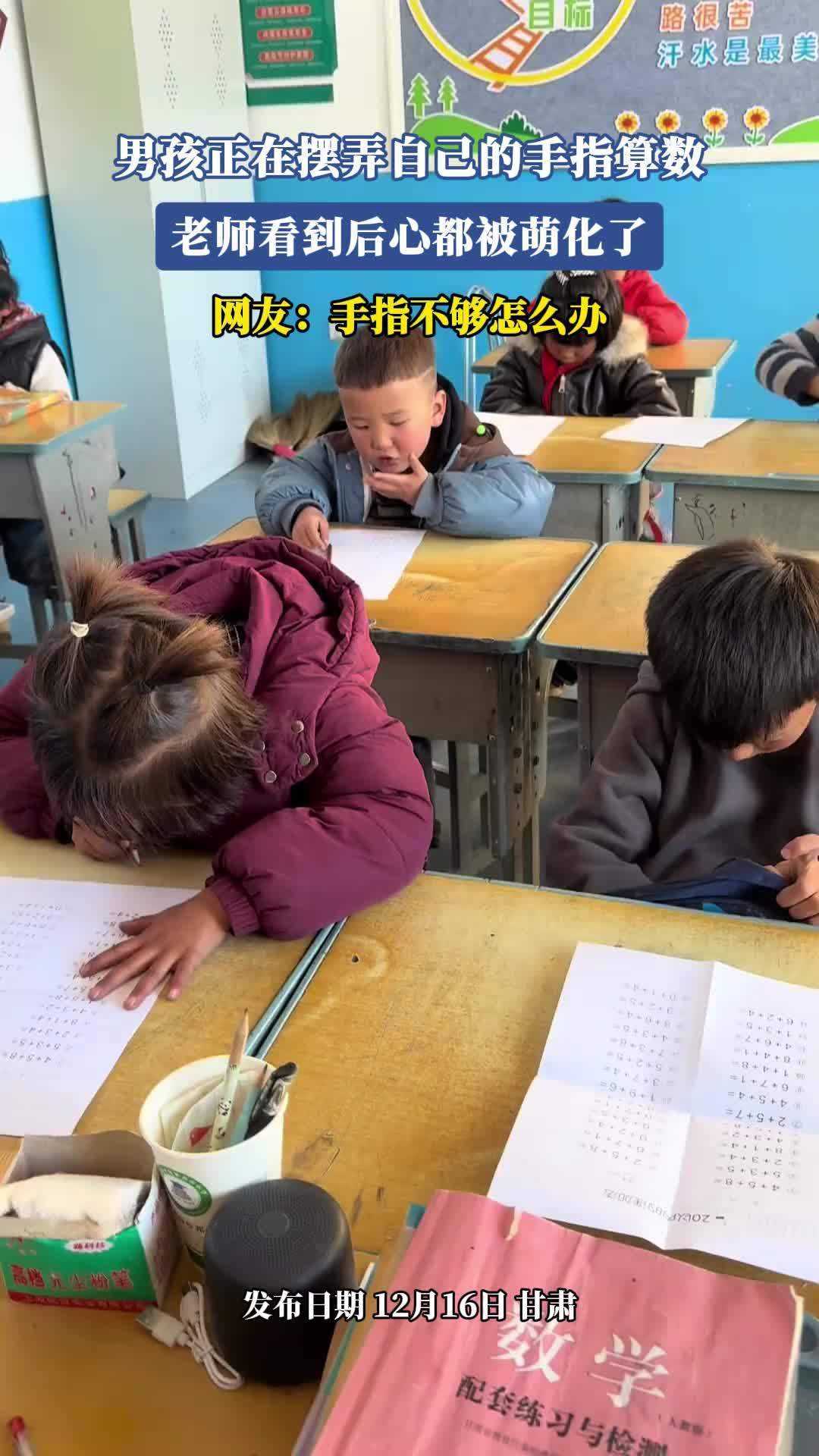 男孩正在摆弄自己的手指算数,老师看到后心都被萌化了