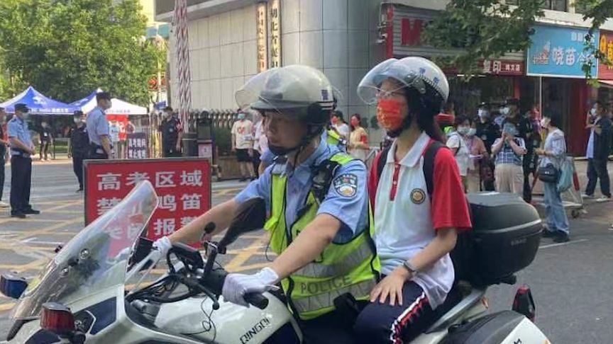 暖!女生晕车不能坐大巴,民警骑铁骑护送考场!