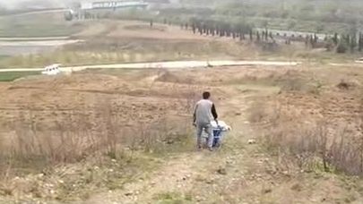 农民小伙用改装的独轮手推车运粮食,很方便啊
