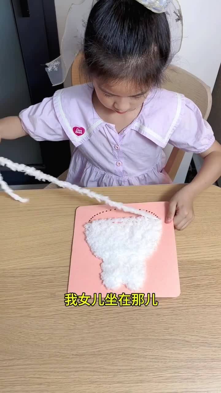 手工:毛线刺绣画 小朋友坐在那儿,手里拿着针线