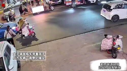 女子骑电瓶车带着孩子,后方车辆一直喇叭催促