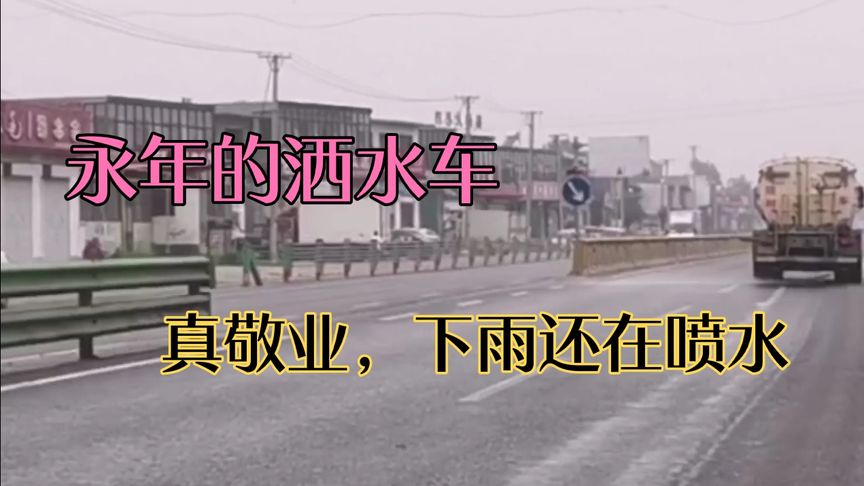 大永年的洒水车,天上下着雨还在喷水作业
