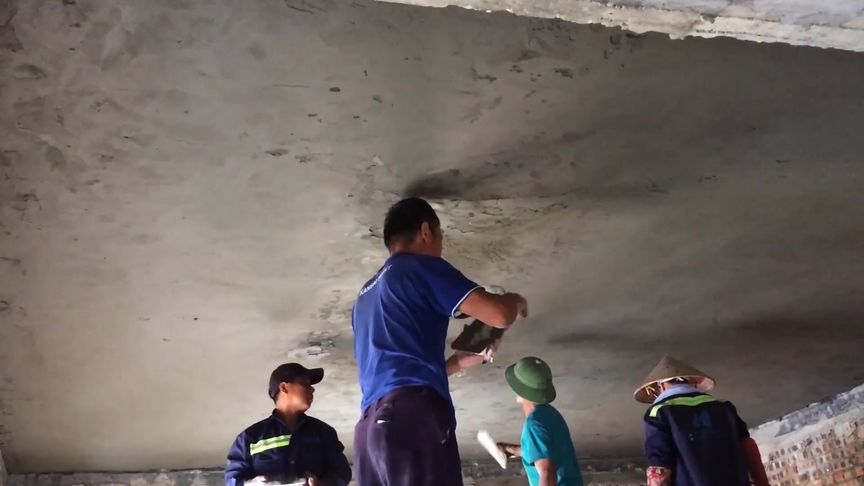 天花板施工过程,泥工师傅在混凝土天花板上涂抹砂和水泥