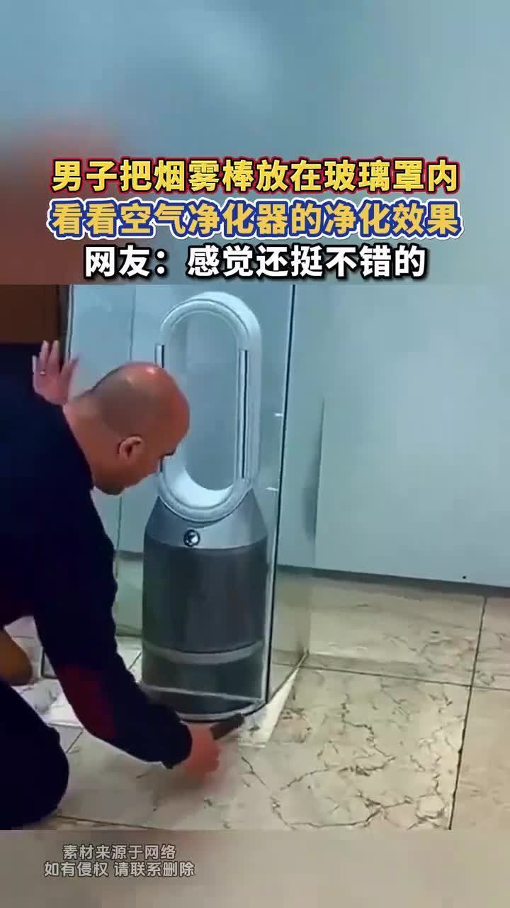 男子把烟雾棒放在玻璃罩内,看看空气净化器的净化效果