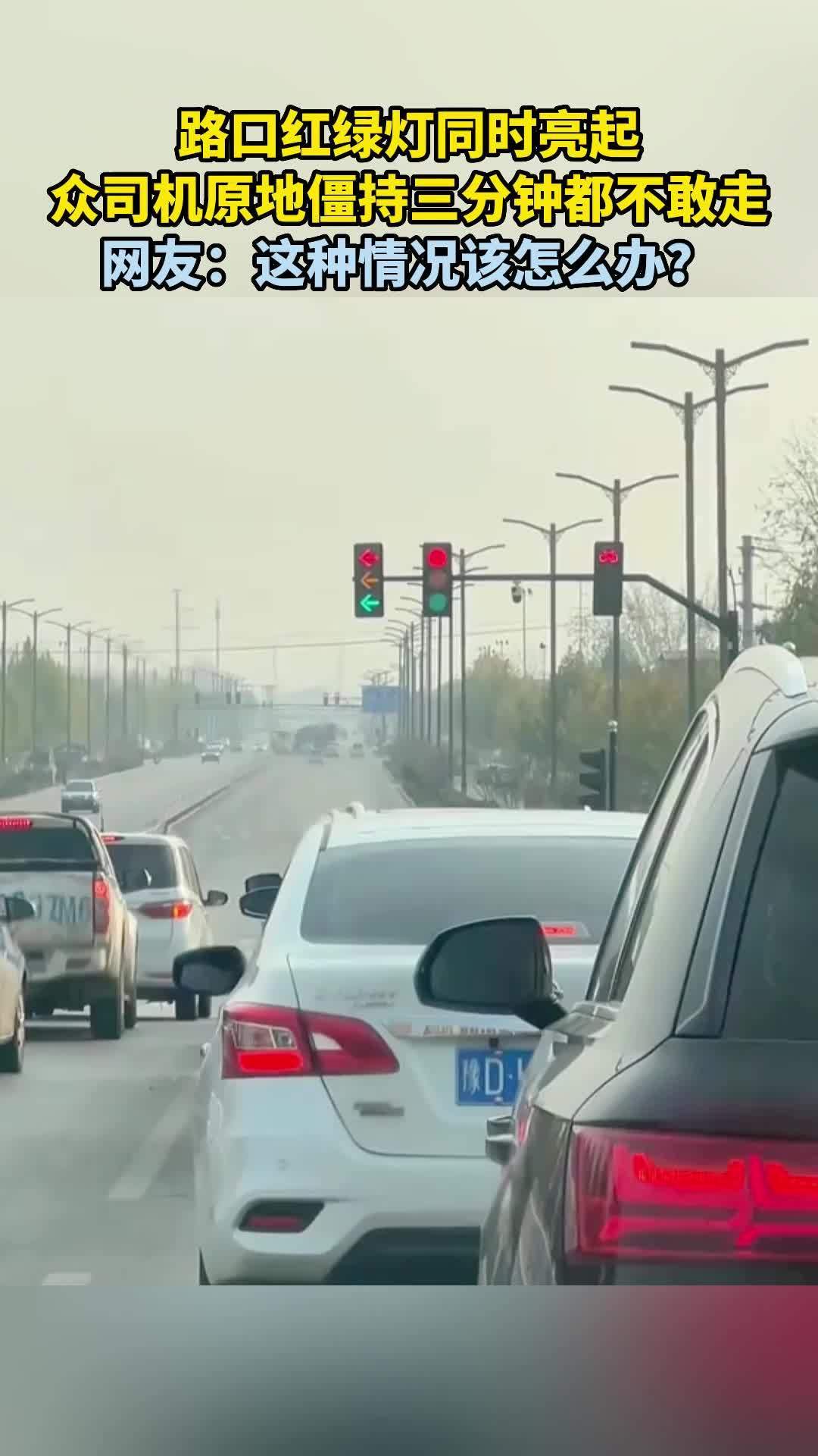 路口红绿灯同时亮起,众司机原地僵持三分钟都不敢走。
