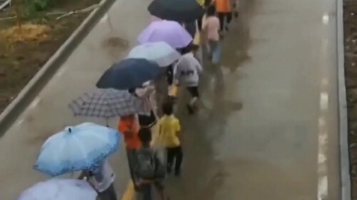 "人工避雨走廊",为了让学生安全走出校门,很多居民都参与进来!
