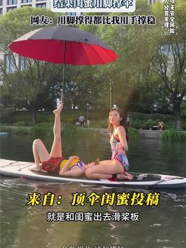 女子和闺蜜划桨板让闺蜜撑伞,结果闺蜜用脚撑伞