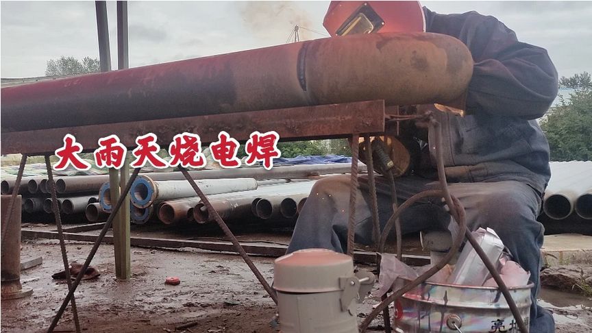 下大雨天烧电焊,打着伞也不行提前下班,抢工期也没办法