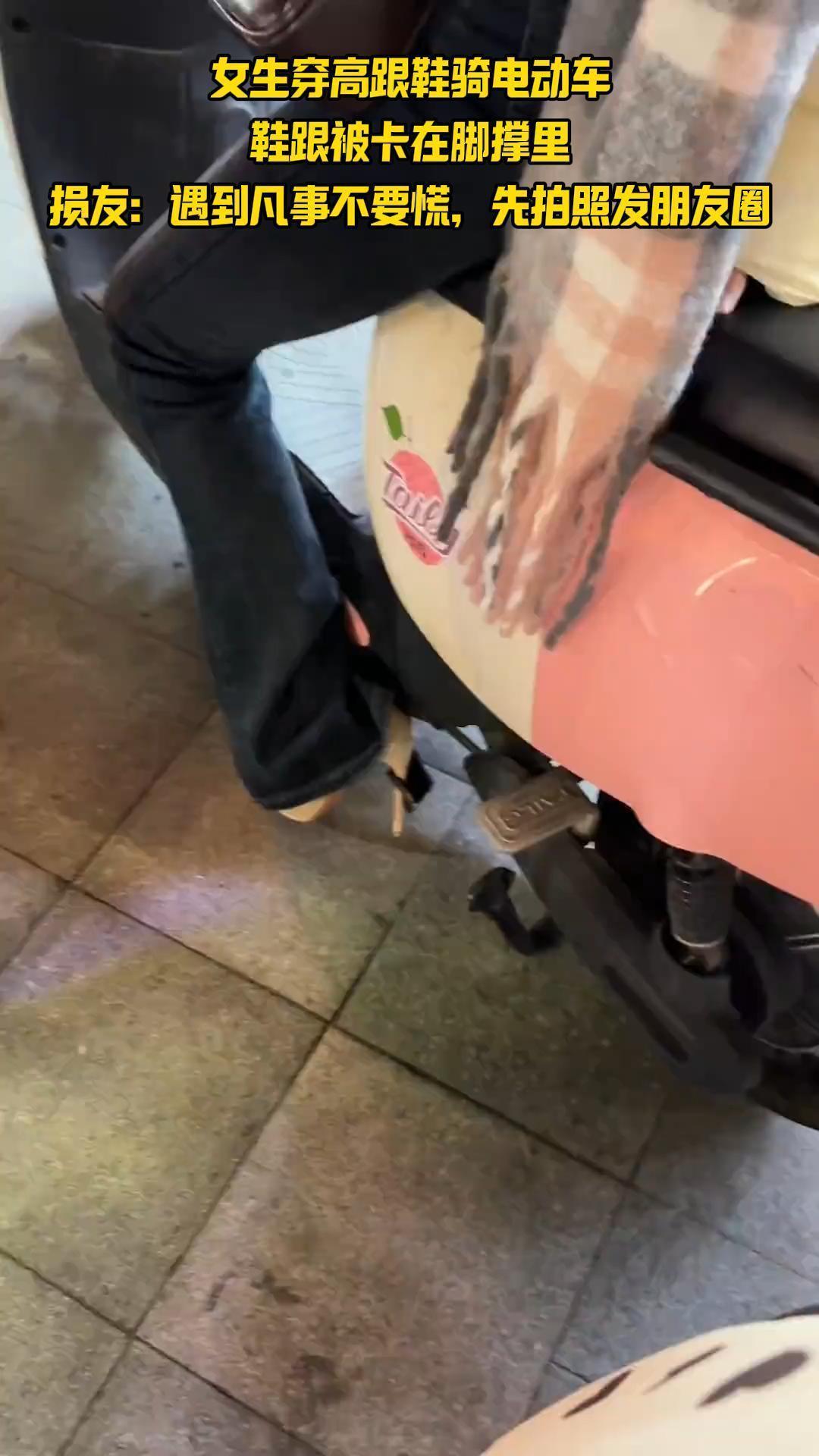 女生穿高跟鞋骑电动车,鞋跟被卡在脚撑里,损友:遇到凡事不要慌,先拍照...
