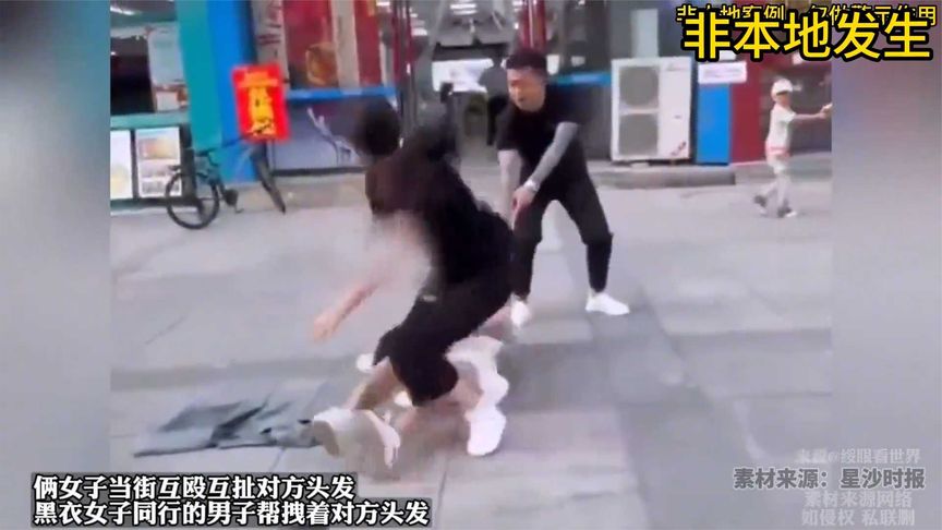 俩女子当街互殴互扯对方头发,黑衣女子同行的男子帮拽着对方头发