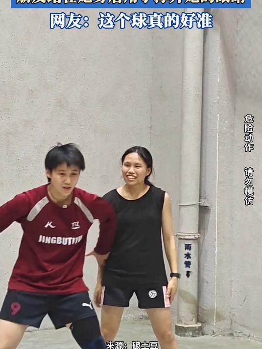 女生在进行排球日常训练,朋友站在她身后用手撑开她的眼睛