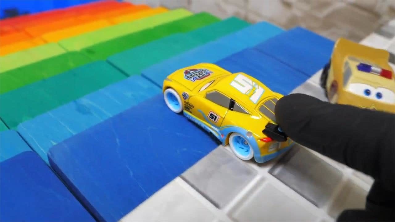 儿童喜欢的赛车总动员玩具车和汽车小伙伴们在彩色台阶滑行入水